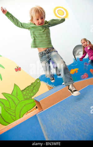 Children jumping over boxes, low angle view Stock Photo - Alamy