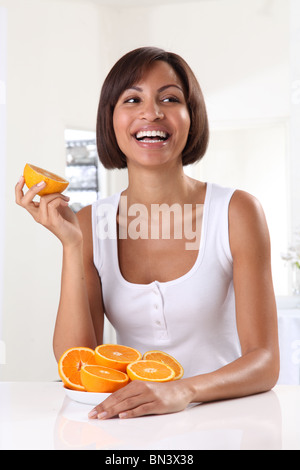 Happy woman holding slices of oranges in front of eyes Stock Photo - Alamy