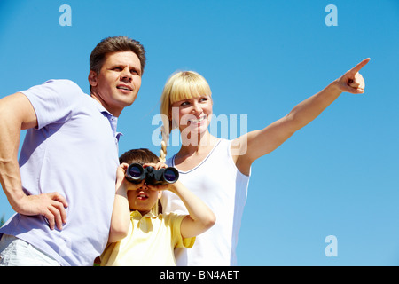 Portrait of family members looking afar outside while standing on cliff ...