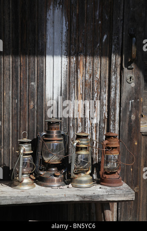 A line of antique gas lanterns sitting on a table in a farm Stock Photo ...