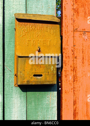 Rusty orange mailbox at wooden fence old house Stock Photo - Alamy