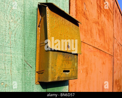Rusty orange mailbox at wooden fence old house Stock Photo - Alamy