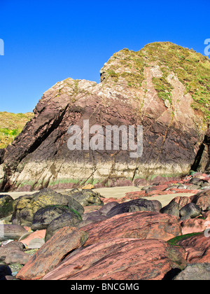 A cliff on a welsh beach under a cloudy sky showing evidence of coastal ...