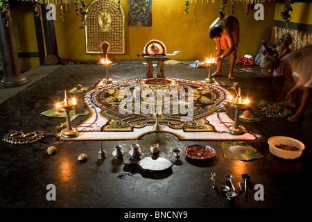 Silver vessels stand ready for a puja (ritual prayer) next to a Kalam ...