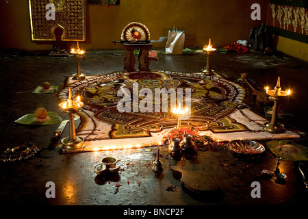Silver vessels stand ready for a puja (ritual prayer) next to a Kalam ...