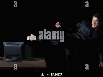 Frustrated businessman kicking a desktop pc Stock Photo - Alamy