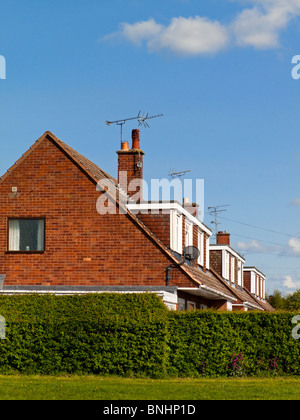 Suburban housing in the UK with 1970s style houses with pitched roofs ...