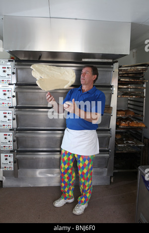 Baker throwing bread dough in bakery Stock Photo - Alamy