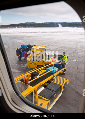 Airport workers load baggage into a luggage vehicle from FlyDubai ...