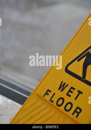 Caution wet floor sign warning of slippery danger in empty office room ...