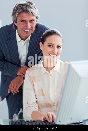 Mature manager helping his colleague work at a computer Stock Photo - Alamy
