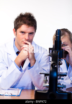 man and woman scientists looking through microscope at laboratory Stock ...
