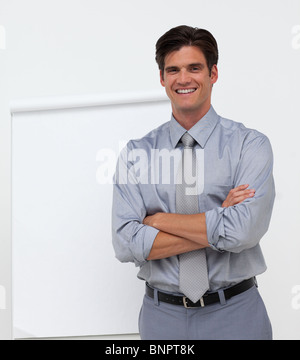 man smiling with folded arms pointing at copy space indoors studio ...