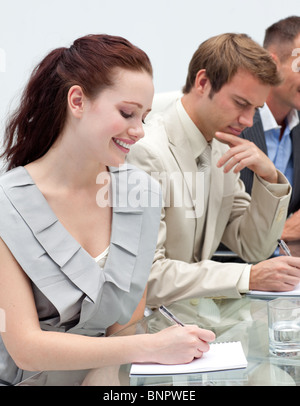 Making notes. an attractive young woman writing in her diary while ...