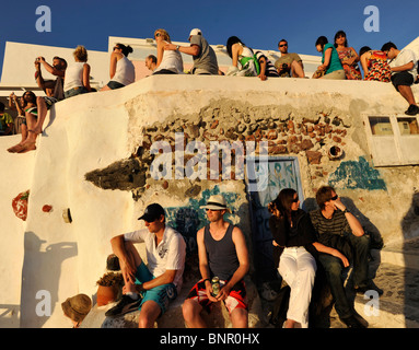 Crowds of young people gathered to see the sunset at Oia, Santorini in ...