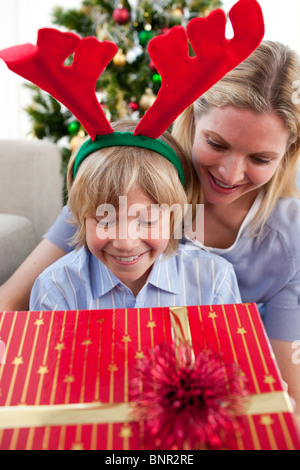 Happy son opening a present with his mother Stock Photo - Alamy