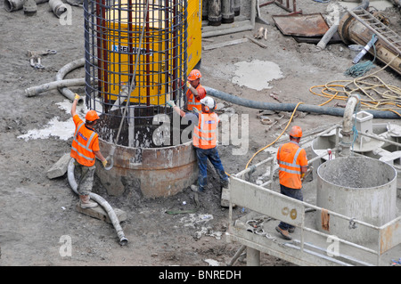 Steel reinforcing cage being lowered by crane into pile casing for ...