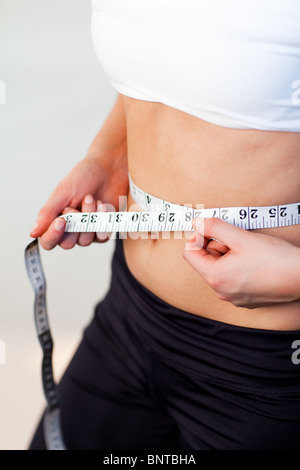 Slim blonde stomach measuring waist with ruler Stock Photo - Alamy