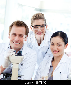 Portrait of male and female scientists in white coats working at ...