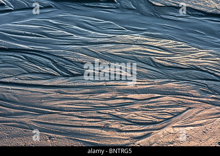 Water patterns on sand with shadows and morning light Stock Photo - Alamy
