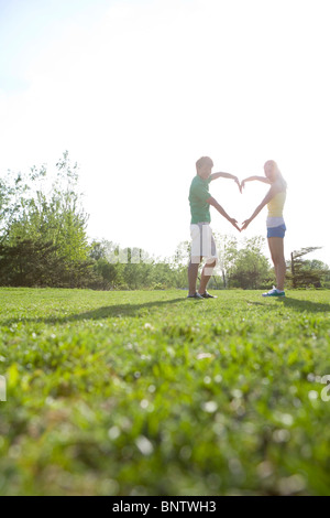 Young Couple Making a Heart with their Arms Stock Photo - Alamy