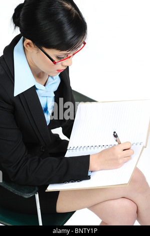 young Asian woman professional writing notes in book at modern office ...