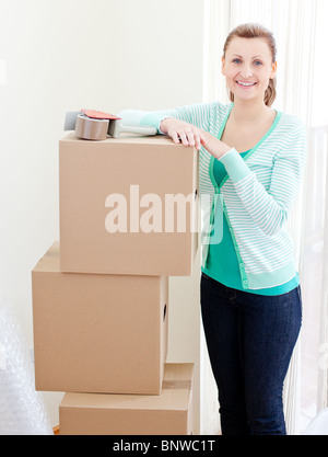 Joyful young woman closing box with kitchen utensils Stock Photo - Alamy