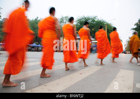 Buddhist monks' feet walking in line on a sidewalk. Luong Probang, Laos ...