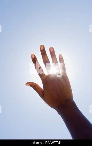 Woman framing sun with her hands in heart shape. Copy space. High ...