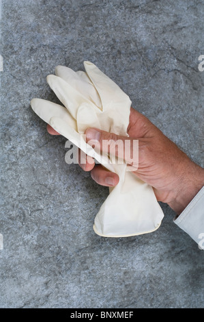 Hands in rubber gloves hold a disposable medical syringe with the drug ...