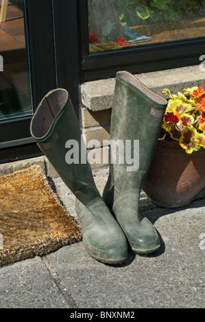 Old worn pair of Green Wellington (Wellies) boots on a concrete floor ...