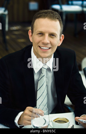 Smiling short-haired man with glass of red wine in one hand Stock Photo ...