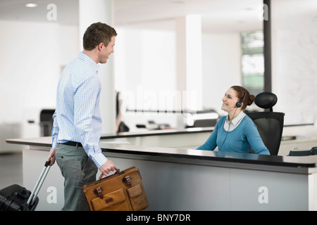 Man receptionist sitting at reception desk. Travel, hospitality Stock ...