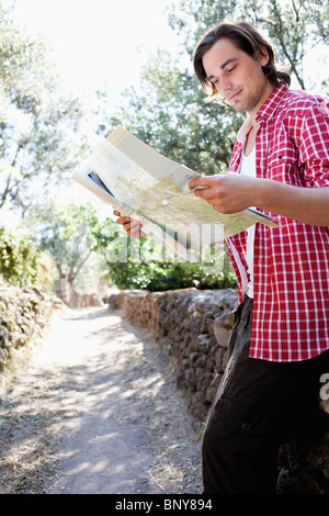 Young man searching for a location from printed map Stock Photo - Alamy
