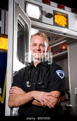 Paramedic in uniform standing with arms folded isolated on white ...