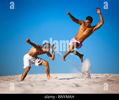 Two men fighting on a beach Stock Photo - Alamy