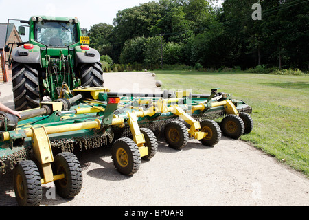 A very large agricultural grass cutting machine or gang mower puled by ...
