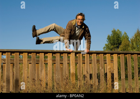Man jumping over fence Stock Photo - Alamy