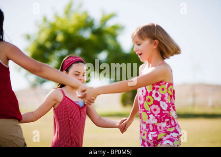 A group of people holding hands and dancing in a circle Stock Photo - Alamy