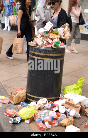 Full garbage bin on the street. Overflowing trashcan on Fifth Avenue in ...