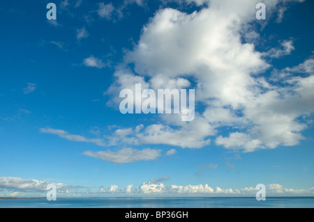 Isolated pretty clouds in the clear sky over a seascape Stock Photo - Alamy
