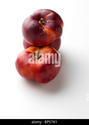 A pile of flat peento nectarines on a white background Stock Photo - Alamy