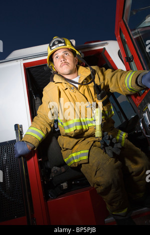 Firefighter exiting fire engine Stock Photo - Alamy