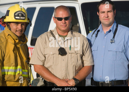 Police officer and paramedic standing side-by-side; during covid-19 ...