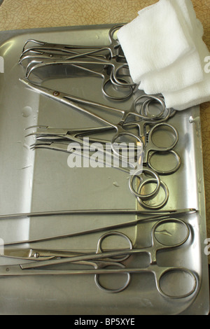 Doctor with surgical equipment needle and scissors. Handsome man weared ...