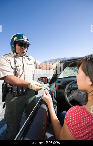 Police officer checking driving license of a car driver during traffic ...