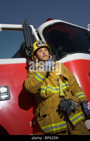 Firefighter using walkie talkie by fire engine Stock Photo - Alamy