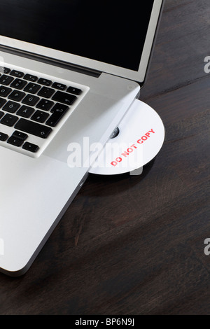 Inserting a CD into a CD rom drive on a laptop computer Stock Photo - Alamy