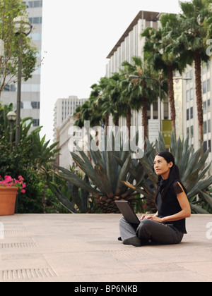 Businesswoman sitting cross-legged on an office chair Stock Photo - Alamy
