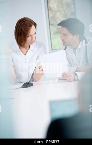Doctors looking at medical report Stock Photo - Alamy